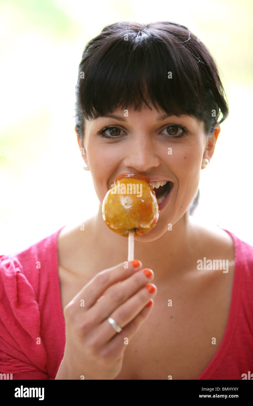 Young Woman Eating a Toffee Apple. Model Released Stock Photo - Alamy