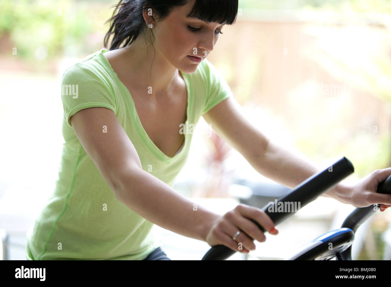 Young Woman Riding Exercise Bike. Model Released Stock Photo - Alamy