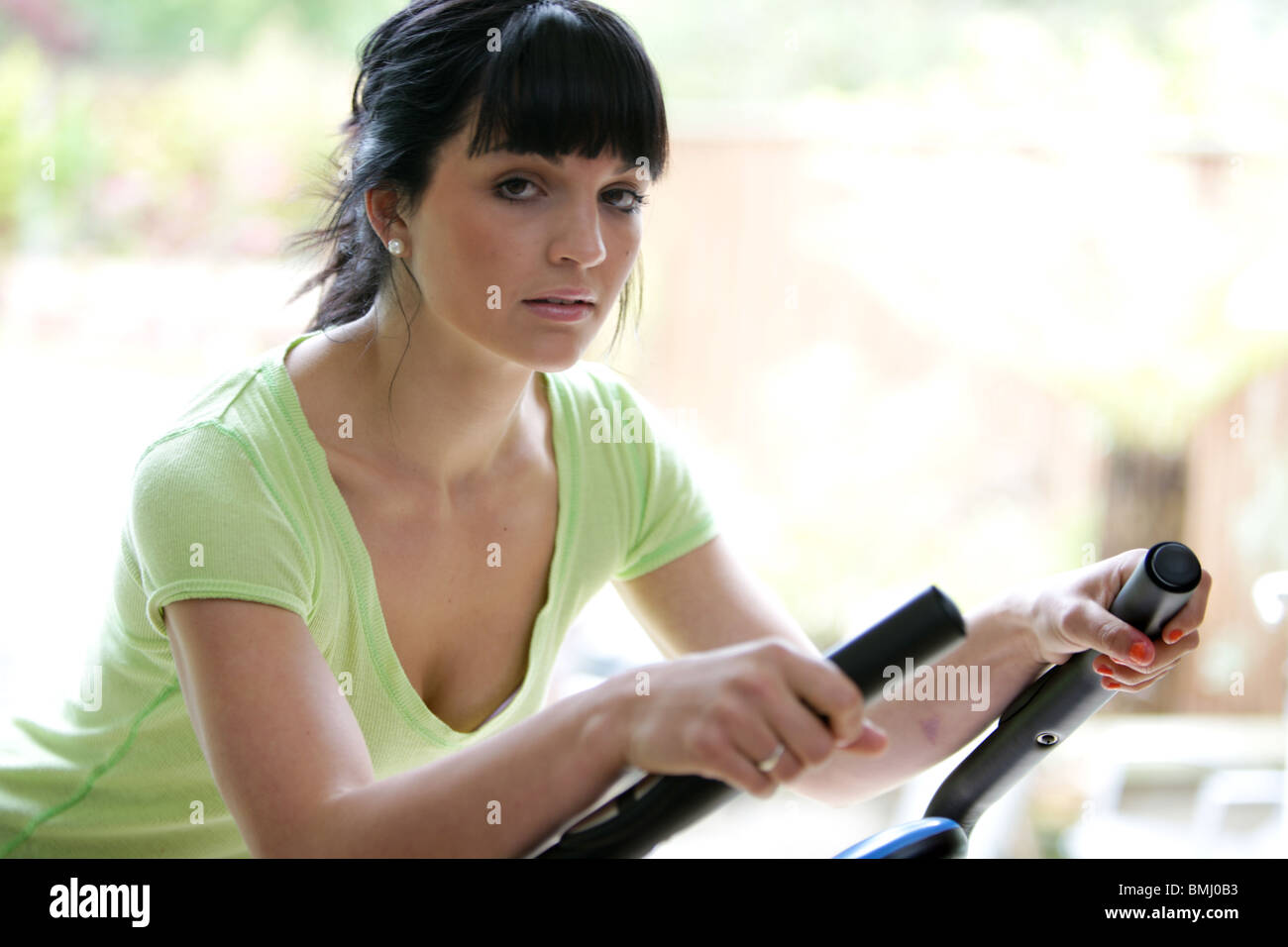 Young Woman Riding Exercise Bike. Model Released Stock Photo - Alamy
