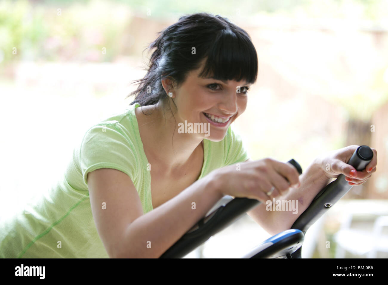 Young Woman Riding Exercise Bike. Model Released Stock Photo - Alamy