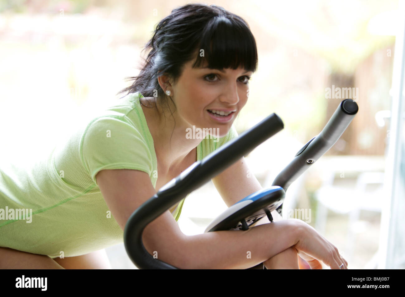 Young Woman Riding Exercise Bike. Model Released Stock Photo - Alamy