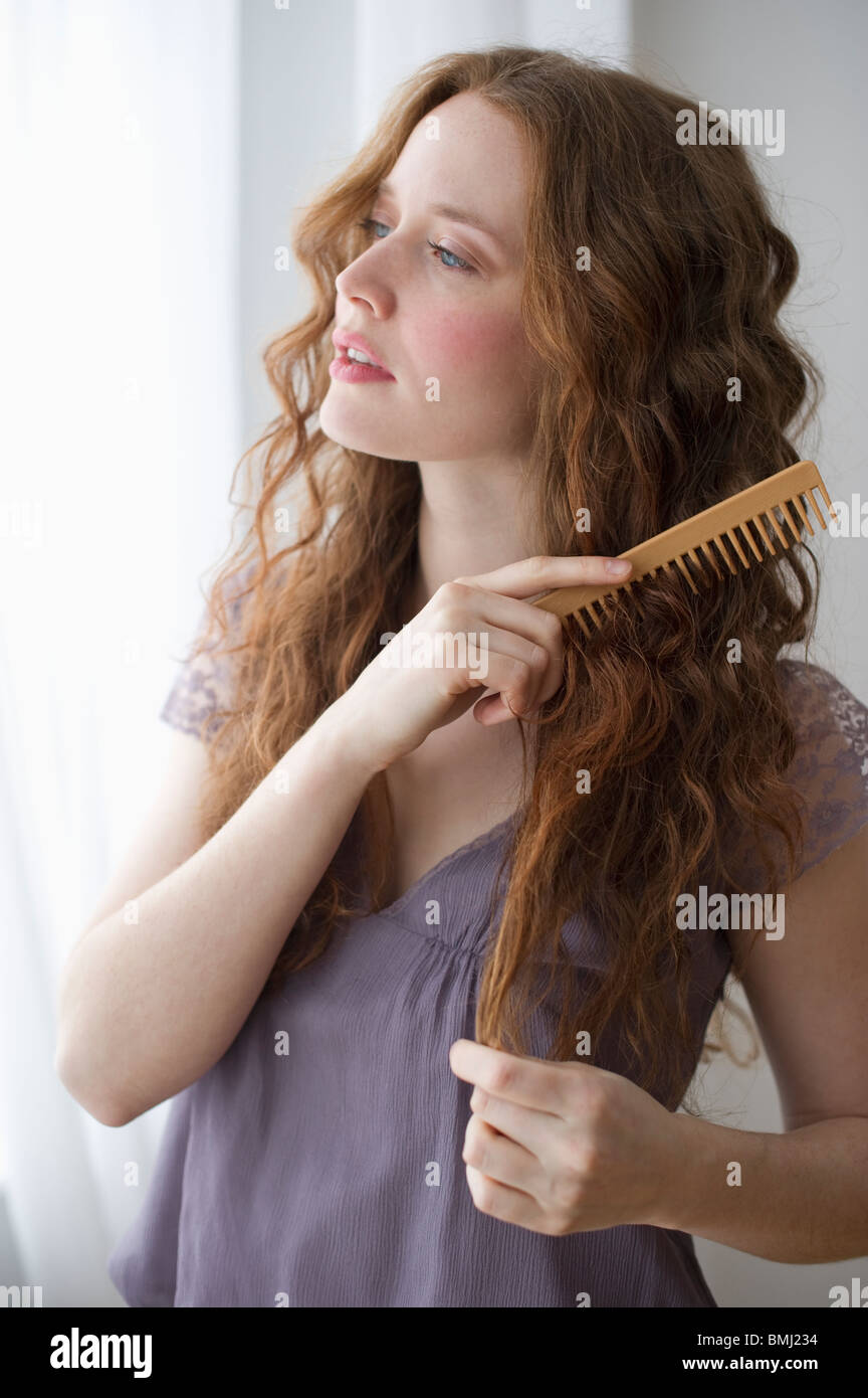 Woman combing her hair Stock Photo - Alamy