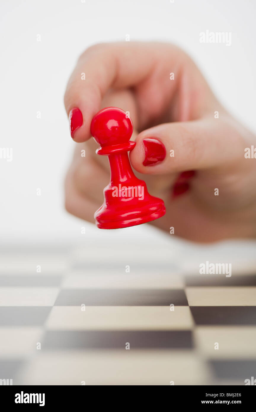 Hand holding red pawn chess piece Stock Photo - Alamy