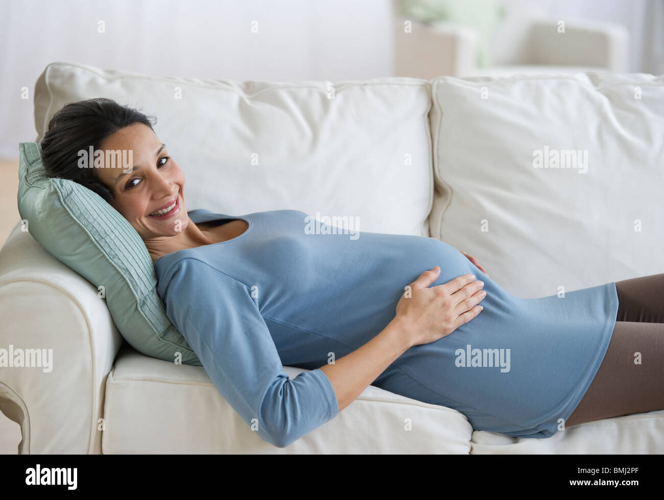 Pregnant mum with family on sofa hi-res stock photography and images ...