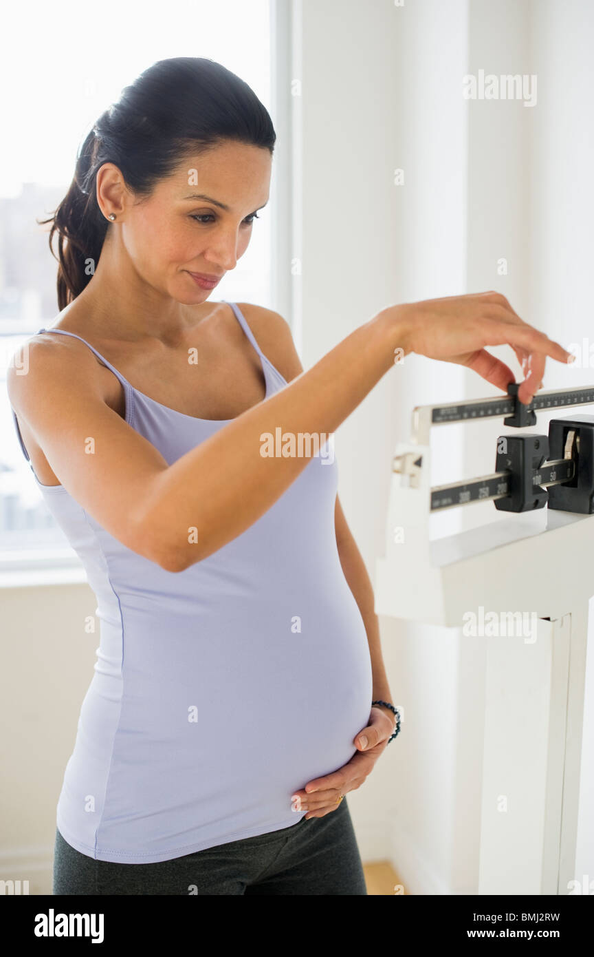 Pregnant woman on scale Stock Photo - Alamy
