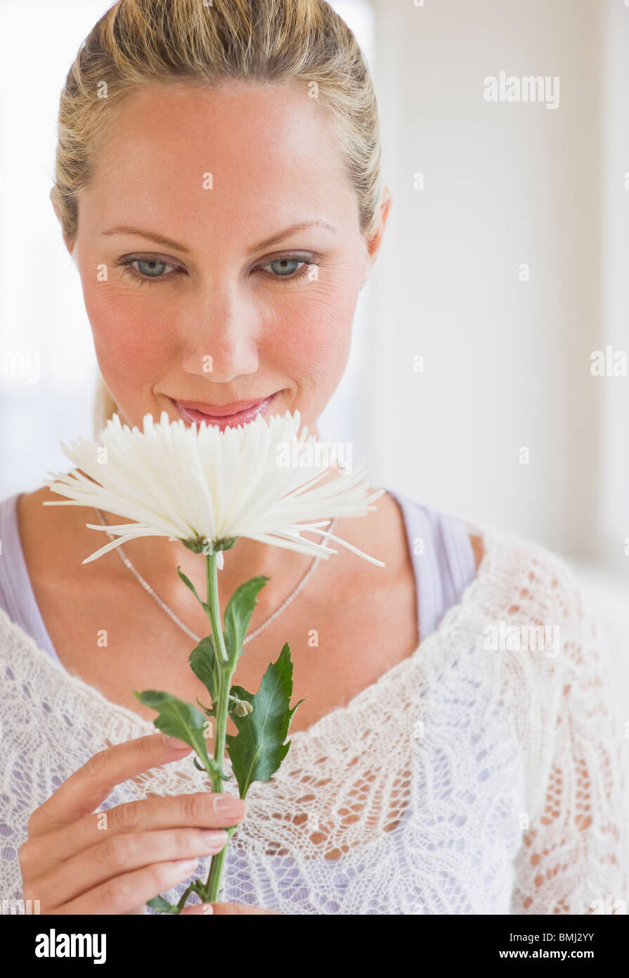 Woman smelling a white flower Stock Photo - Alamy
