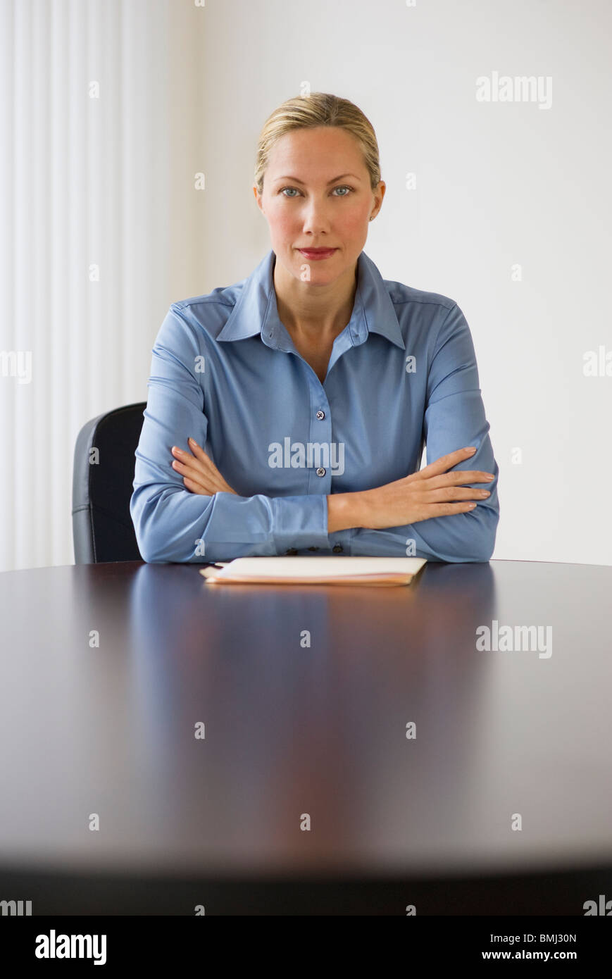 Businesswoman sitting at conference table Stock Photo - Alamy