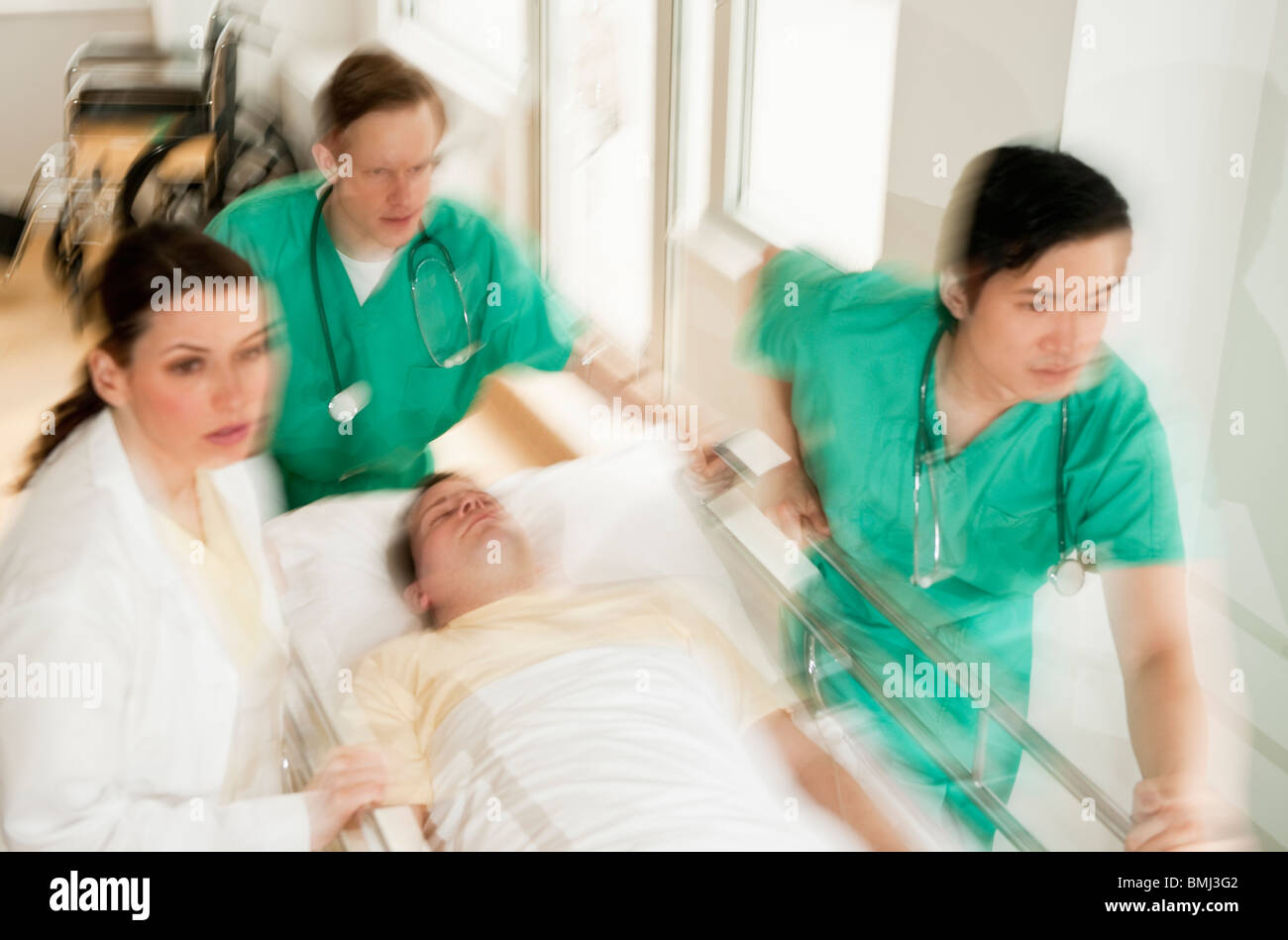 Healthcare workers pushing gurney in emergency room Stock Photo - Alamy