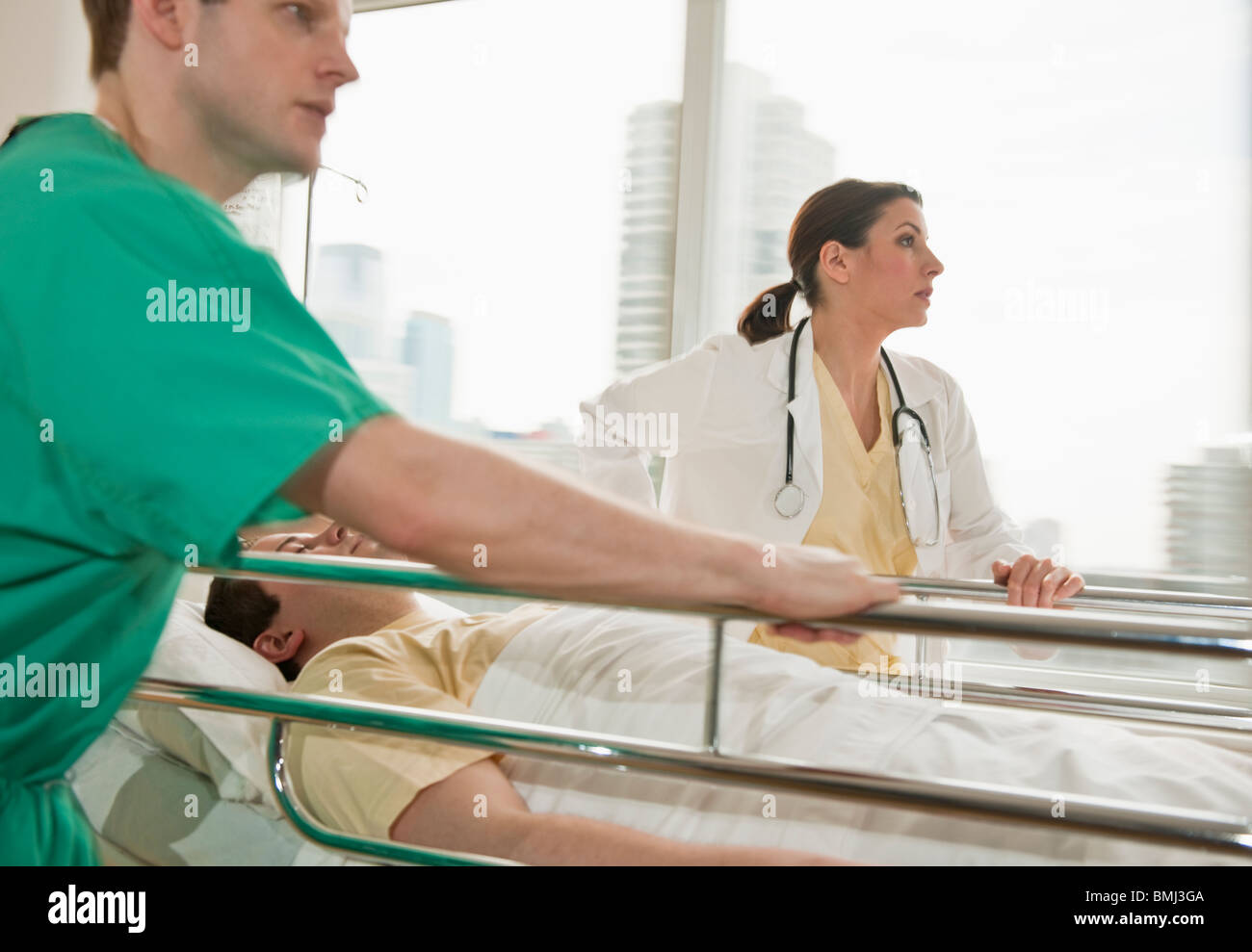 Healthcare workers pushing gurney in emergency room Stock Photo - Alamy