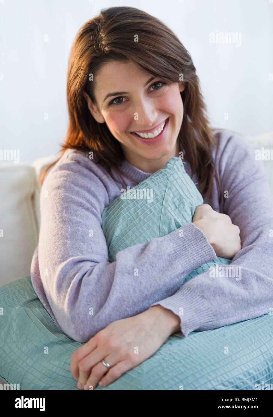 Woman hugging a pillow Stock Photo - Alamy