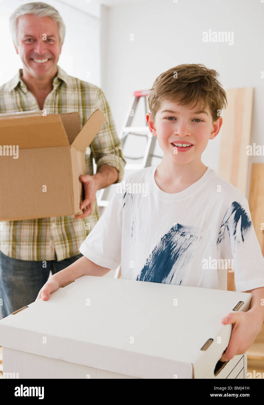 Father and son carrying moving boxes Stock Photo - Alamy
