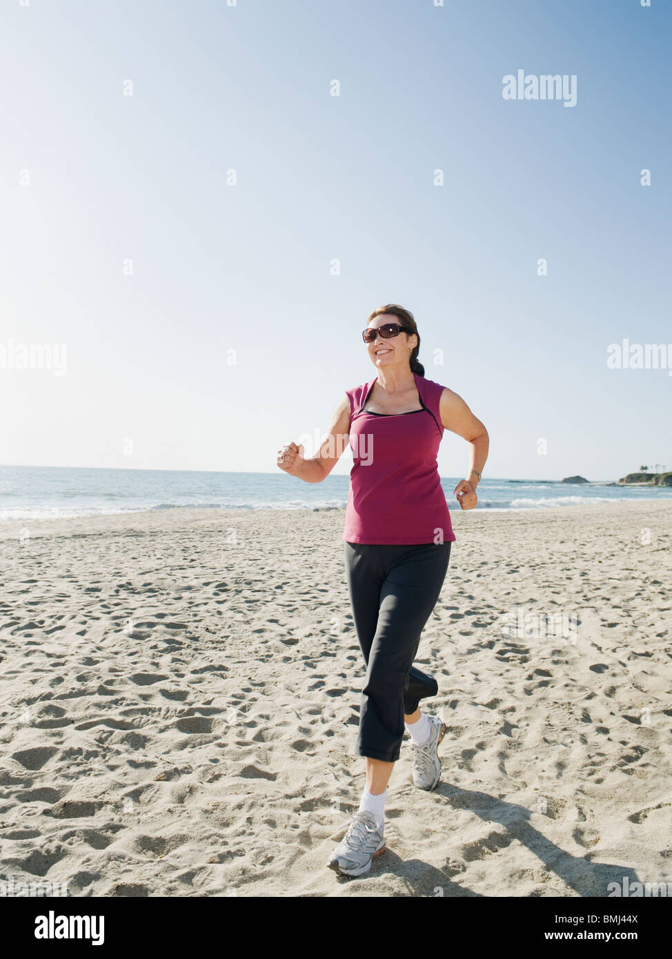 Woman jogging on beach Stock Photo - Alamy