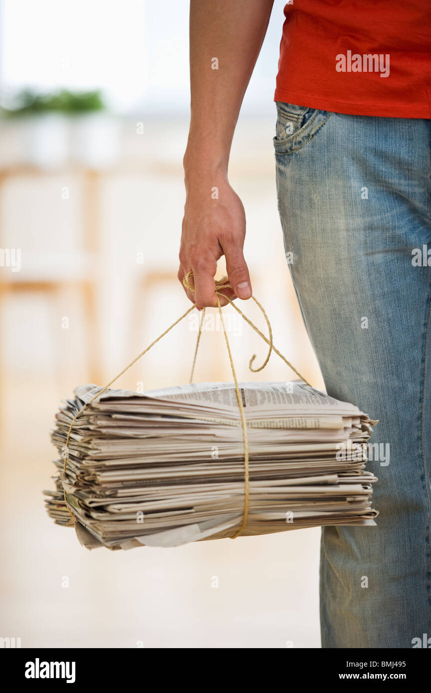 Man holding stack of newspapers Stock Photo - Alamy