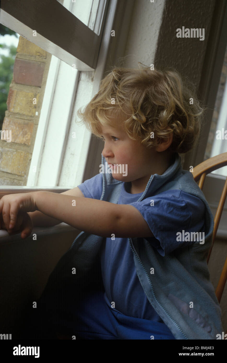 boy sitting waiting at open window Stock Photo - Alamy