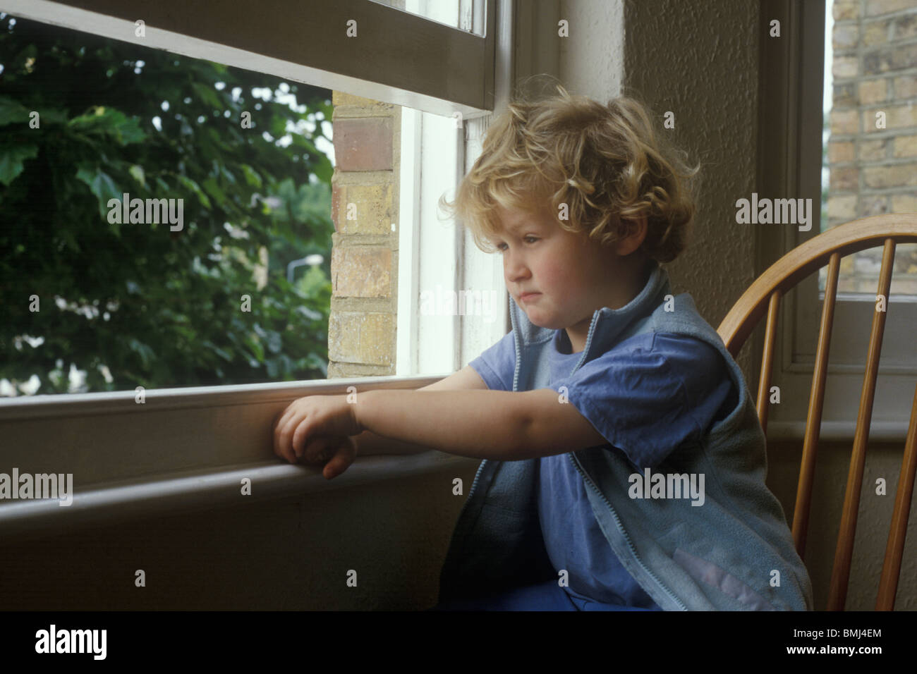 boy sitting waiting at open window Stock Photo - Alamy