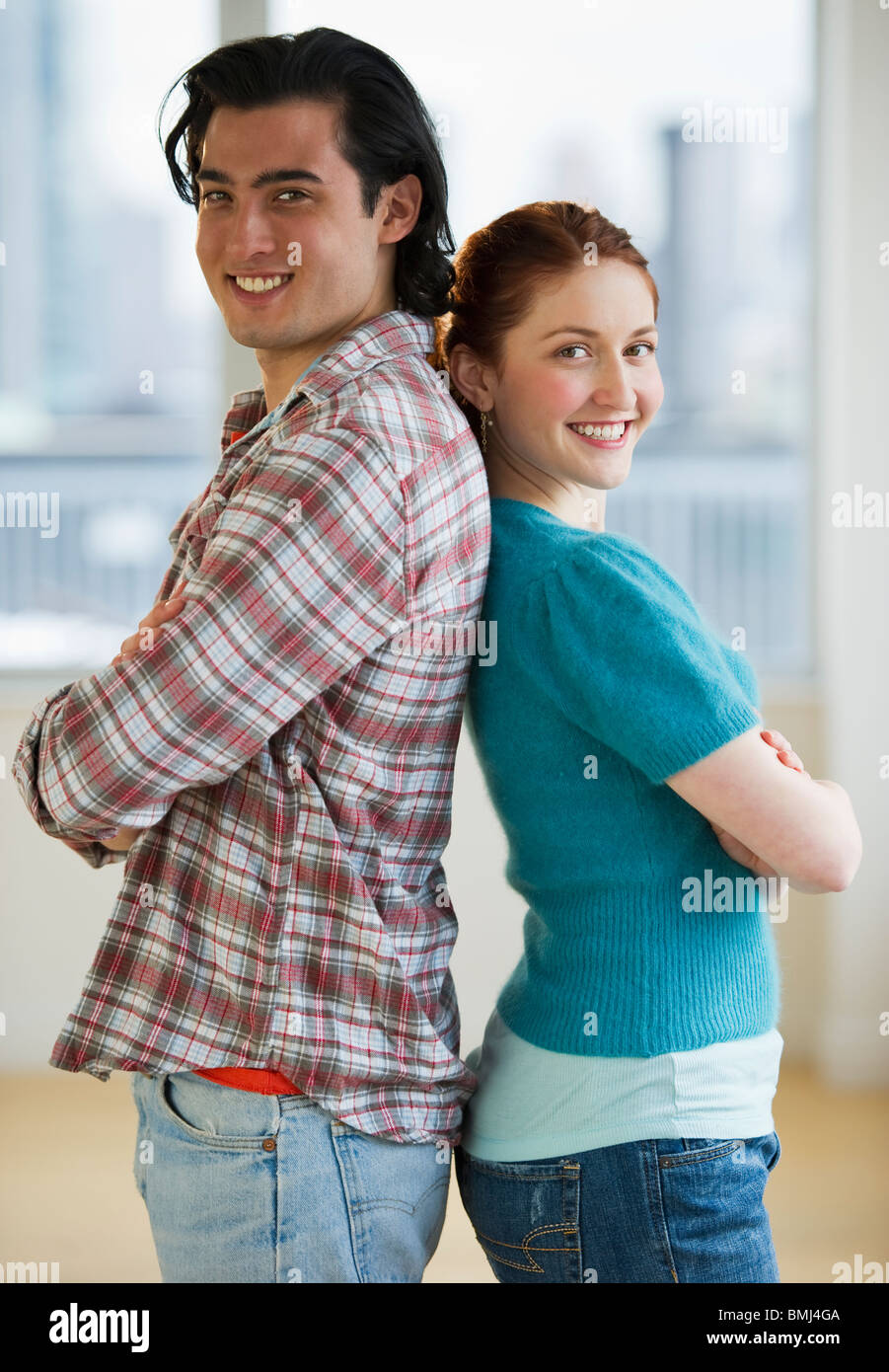Couple standing back to back Stock Photo - Alamy