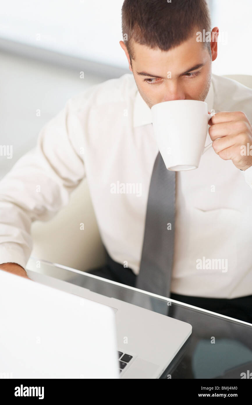 Businessman drinking coffee at desk Stock Photo - Alamy