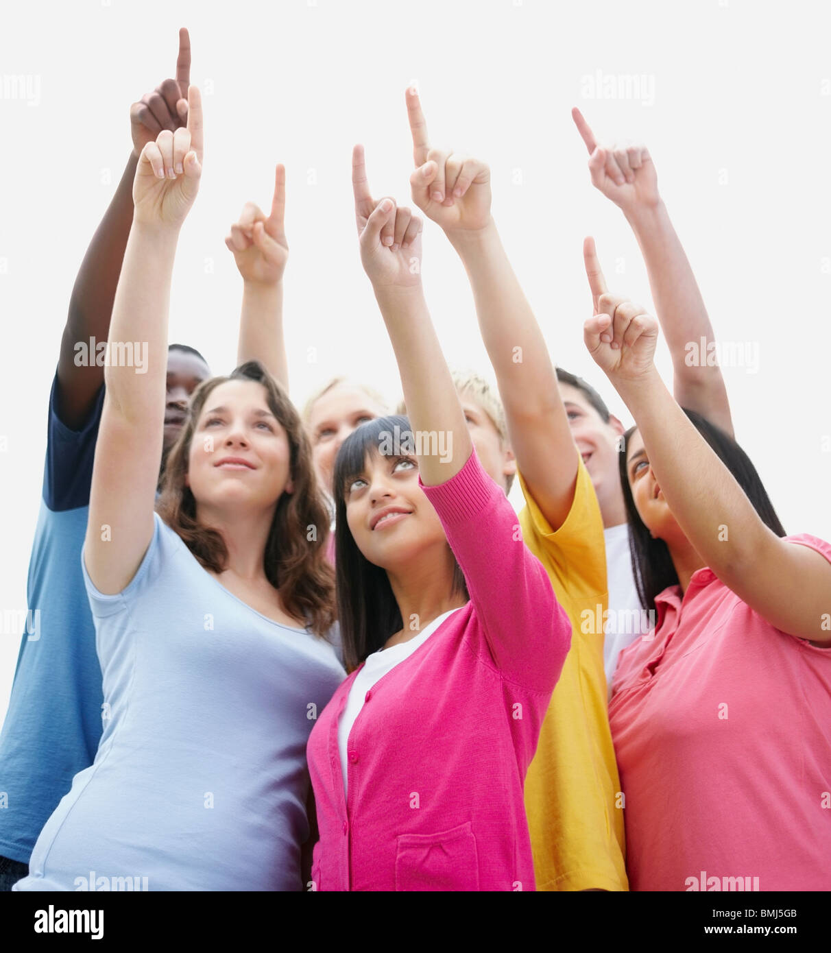 Group of friends pointing up Stock Photo - Alamy