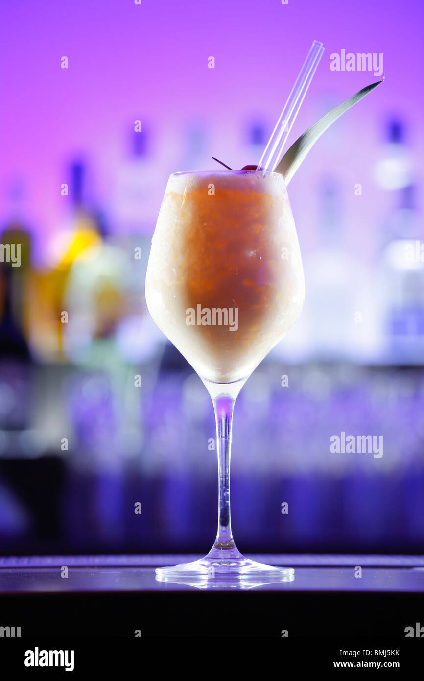 Pina Colada cocktail on a bar, purple background Stock Photo - Alamy