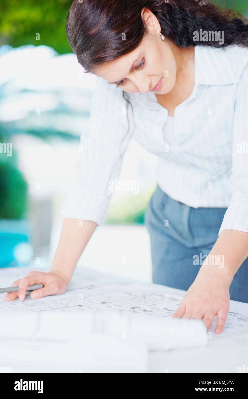 Woman looking at blueprints Stock Photo - Alamy