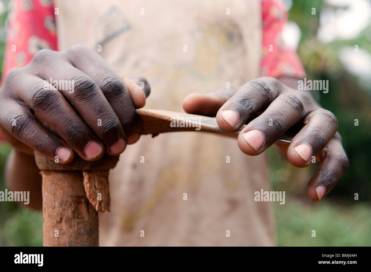 Close up of childs hand holding a hoe. Rwanda Stock Photo - Alamy