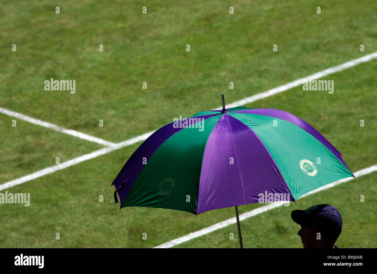 a ball boy at wimbledon with a brolly as sun shade Stock Photo - Alamy