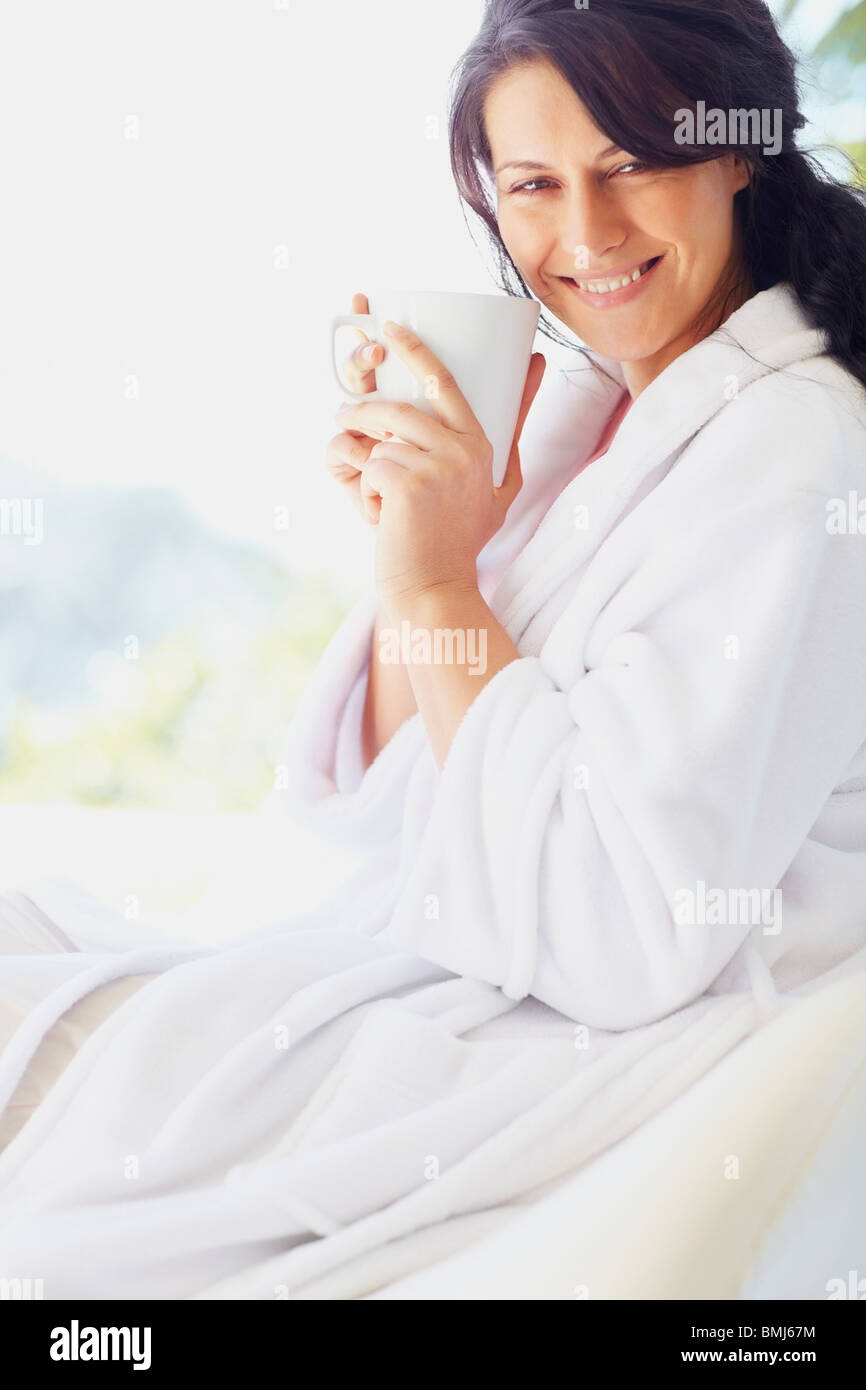 Woman in bathrobe drinking coffee Stock Photo - Alamy