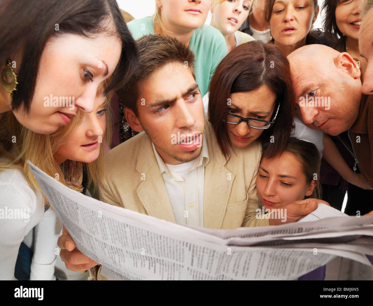 group of people reading one newspaper Stock Photo - Alamy