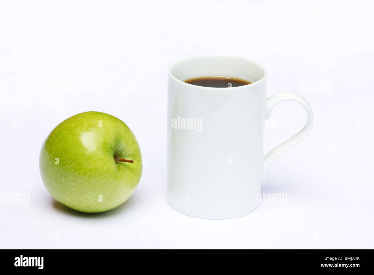 Close-up of green apple and mug of coffee on white background Stock ...