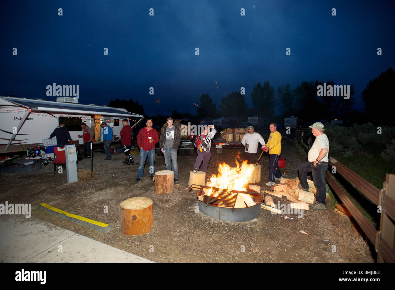 Group of friends around a campfire Stock Photo - Alamy