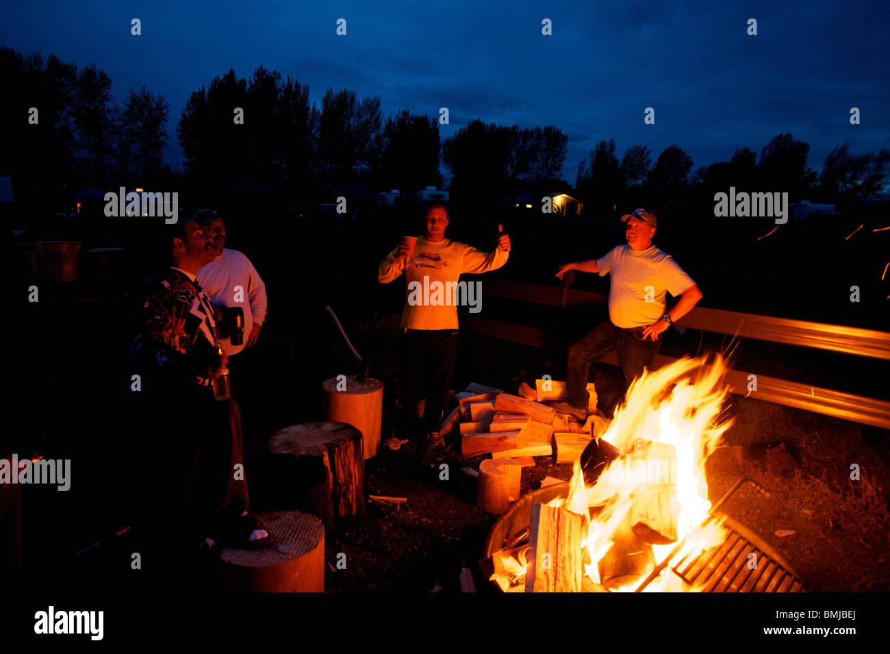 Group of friends around a campfire Stock Photo - Alamy