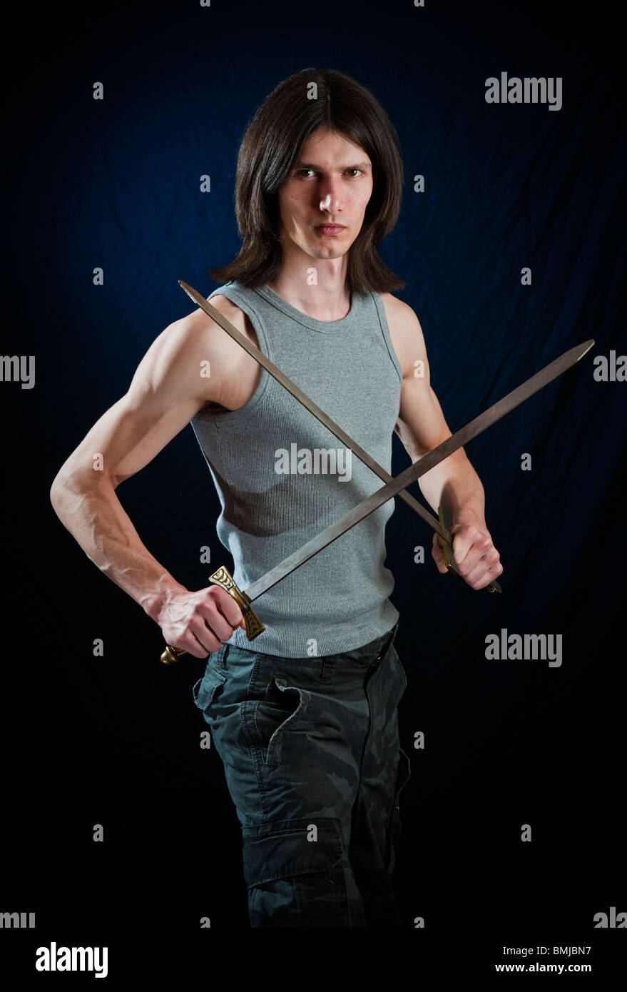 A young man with two swords Stock Photo - Alamy