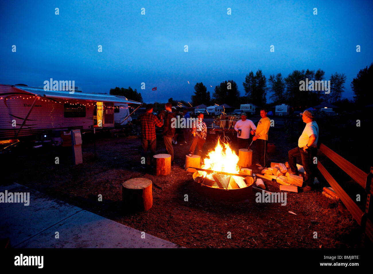 Group of friends around a campfire Stock Photo - Alamy