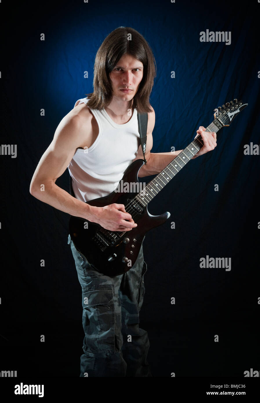A young man playing an electric guitar Stock Photo - Alamy