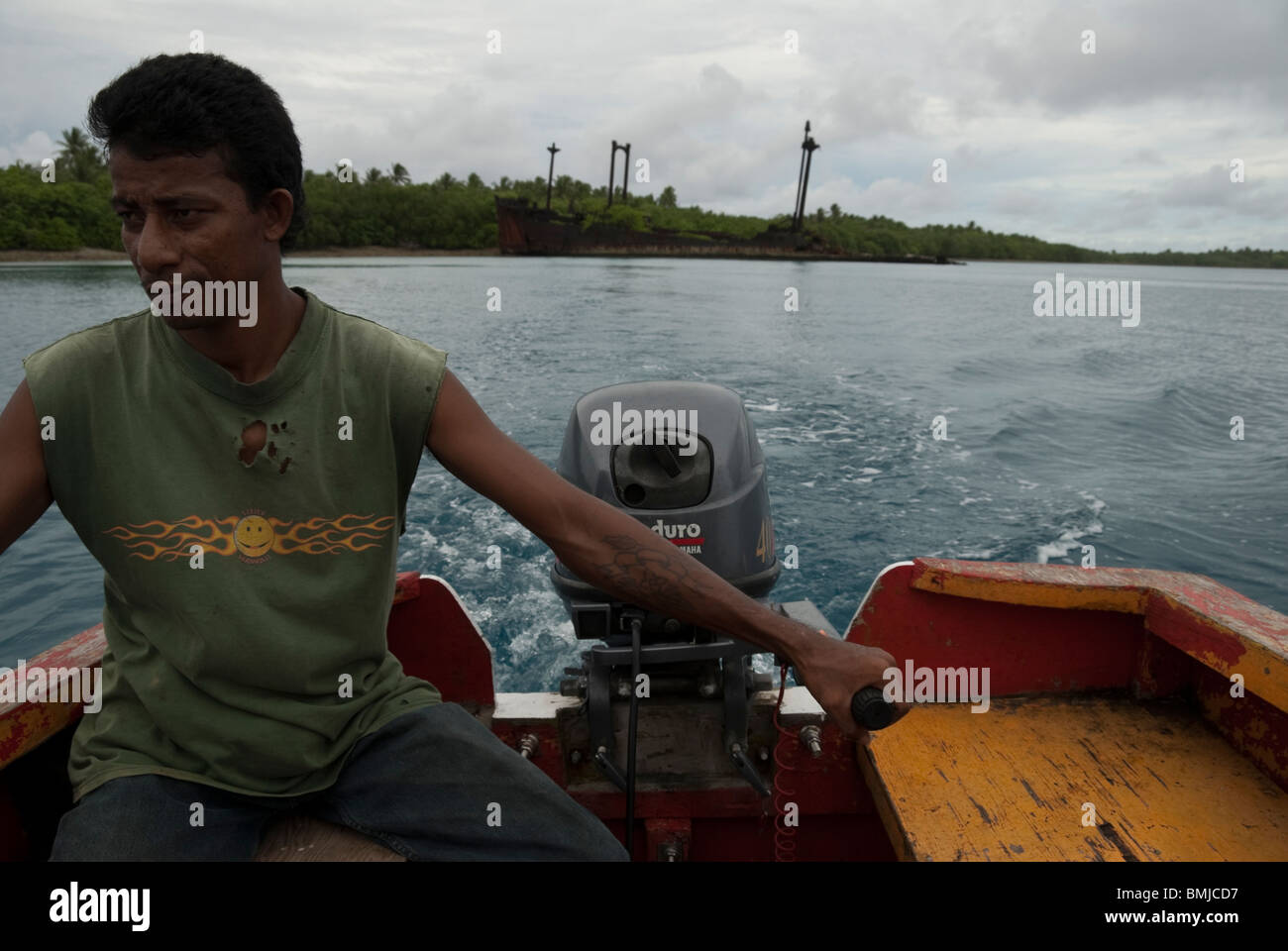 A Marshallese man steers his outboard away from a WWII wreck near Imej ...