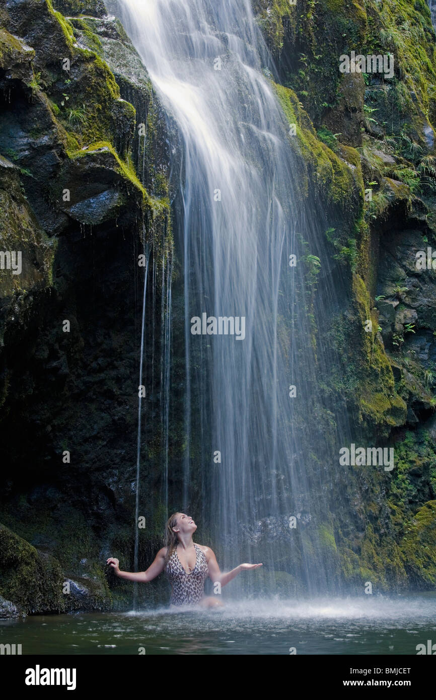 Woman enjoys a waterfall on the road to Hana, Maui, Hawaii, USA Stock ...