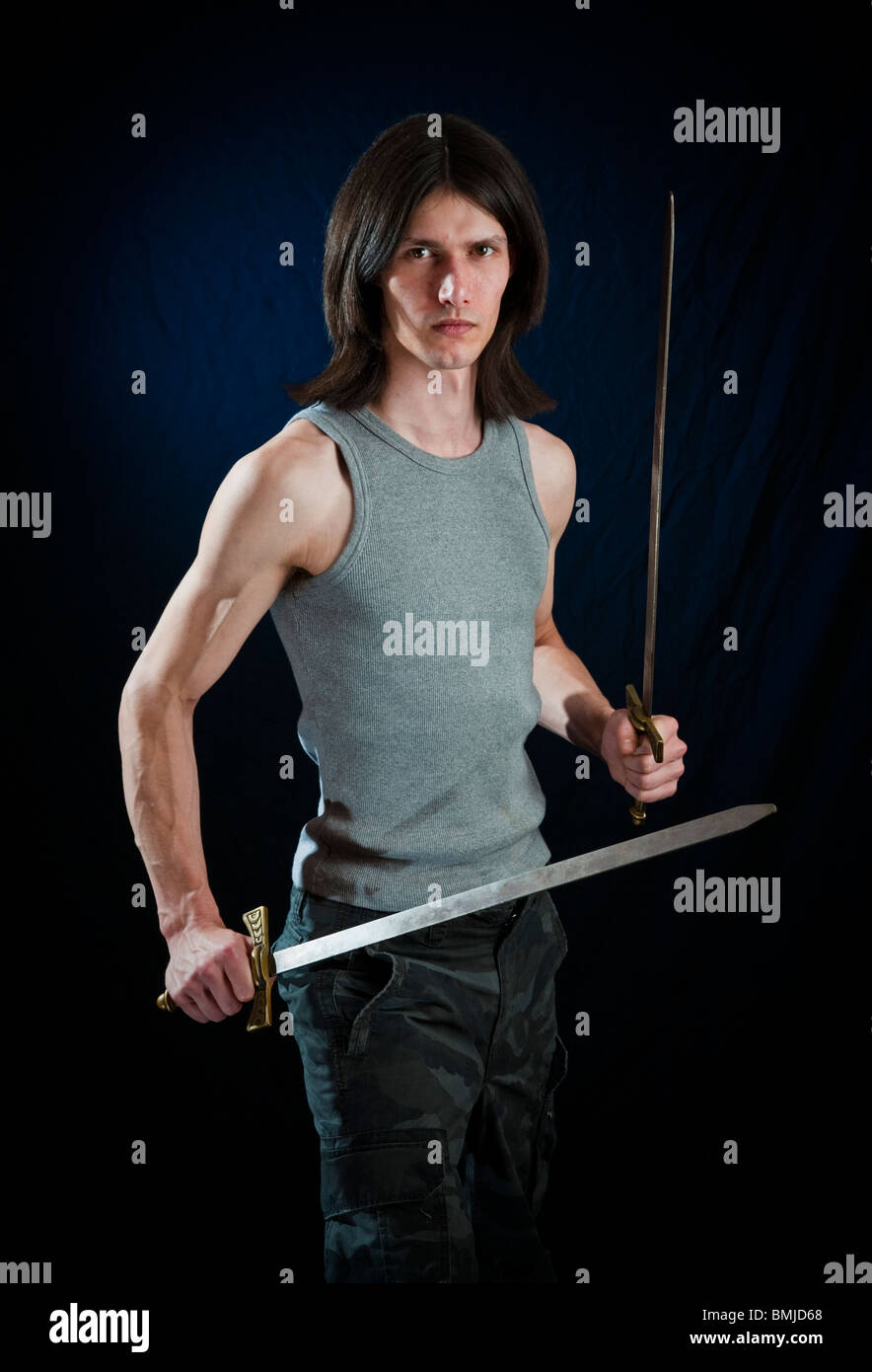 A young man with two swords Stock Photo - Alamy