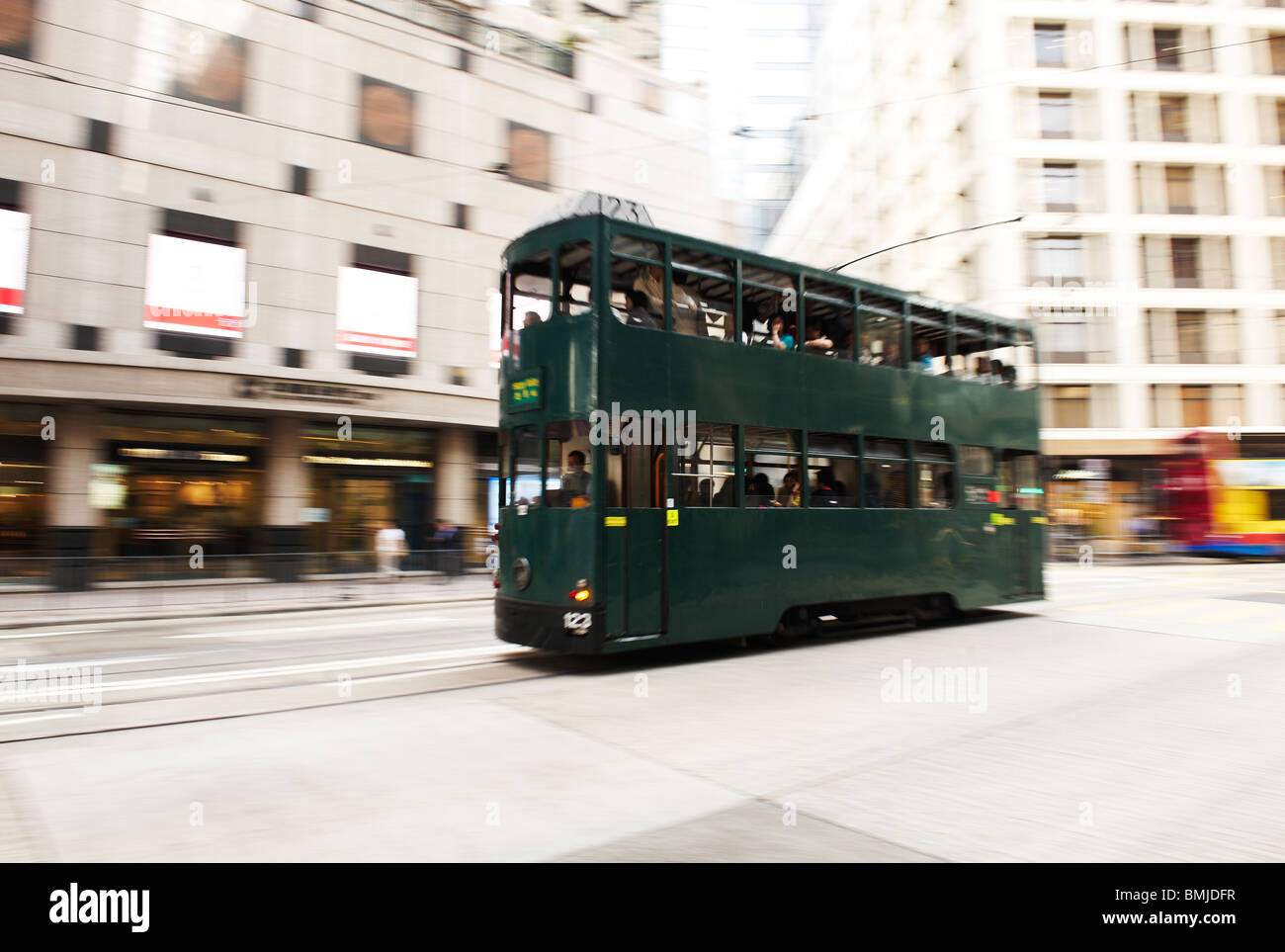 An old style double decker bus moving across downtown Hong Kong, the ...
