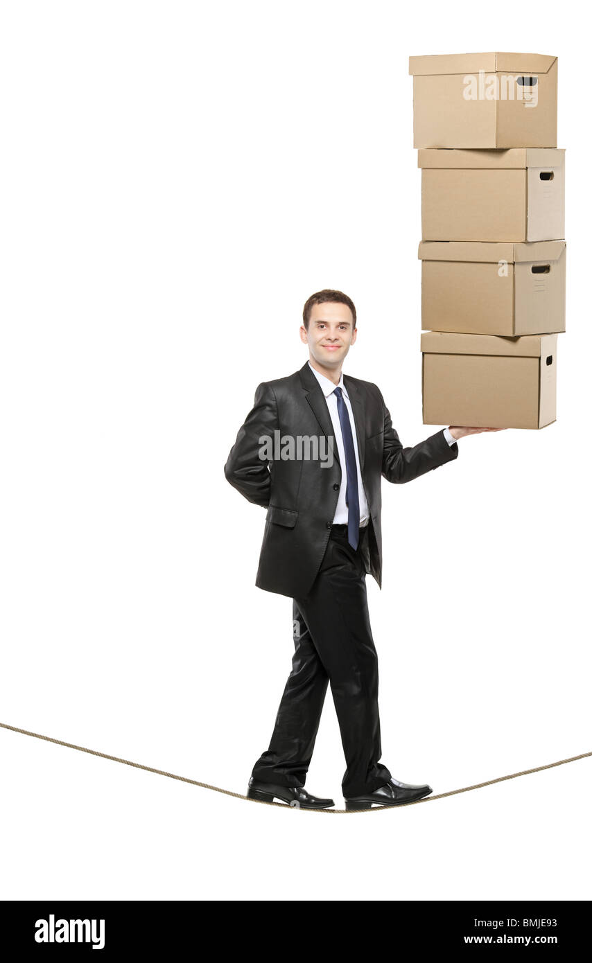 A businessman holding paper boxes and walking on a rope Stock Photo - Alamy