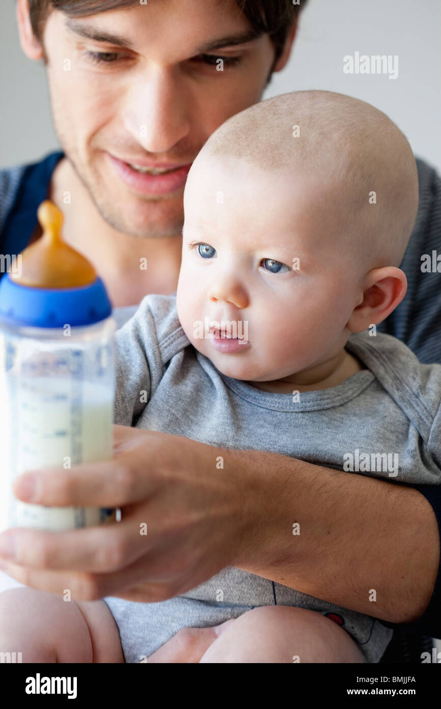 Father offering baby bottle Stock Photo - Alamy