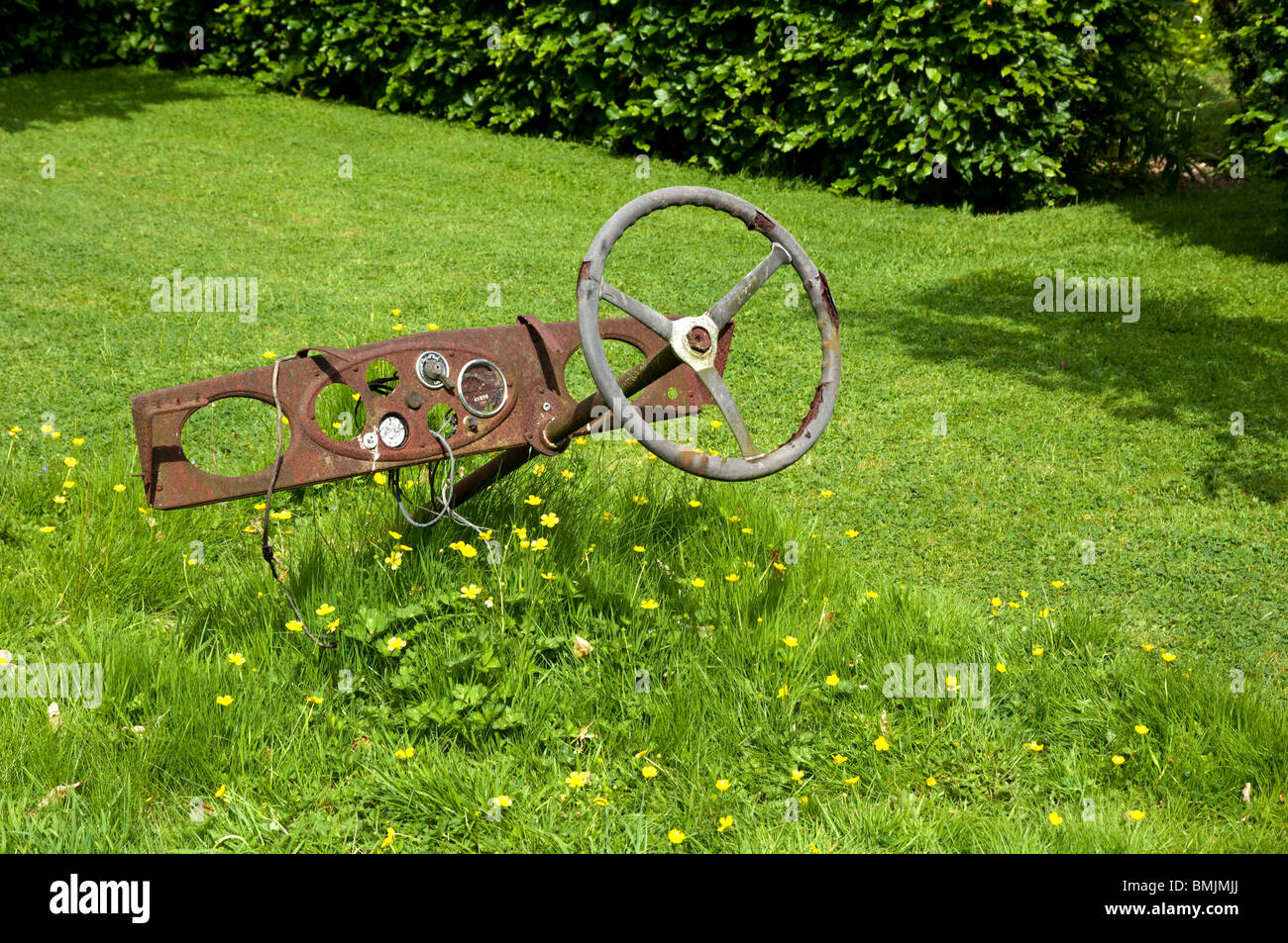 Humorous sculpture of a rusty driving wheel and dashboard, in long ...