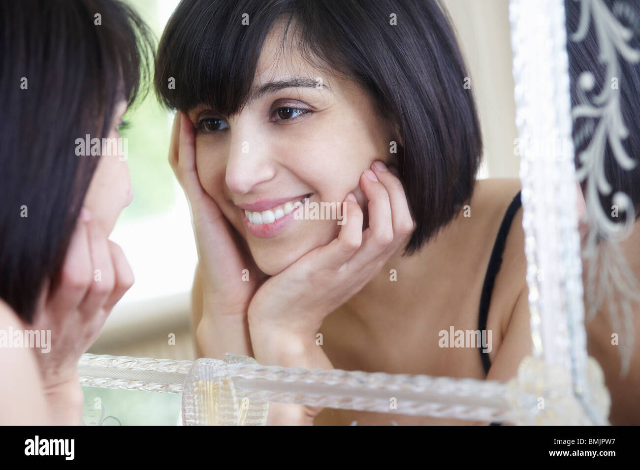 Woman looking in the mirror Stock Photo - Alamy