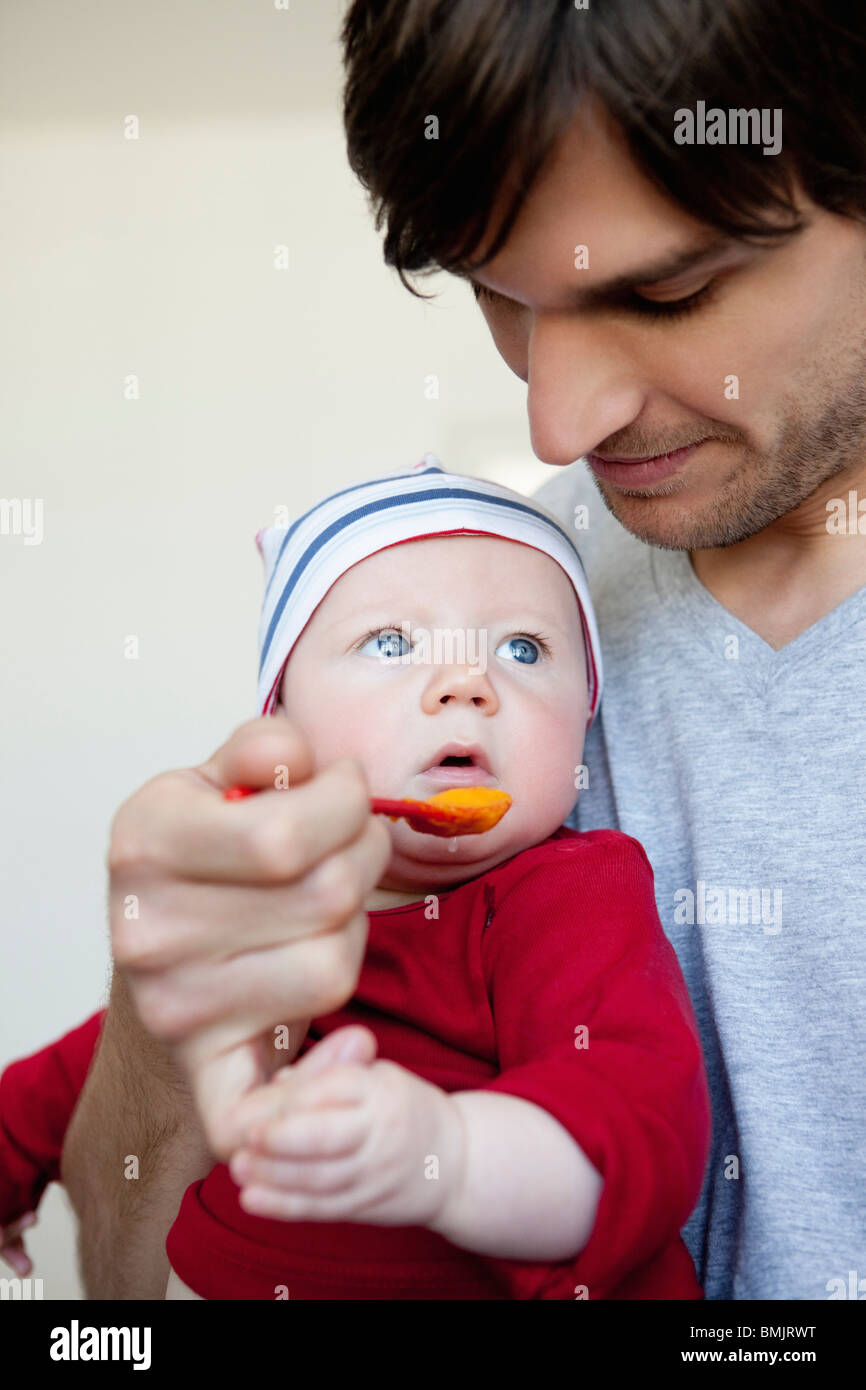 Man feeding baby Stock Photo - Alamy