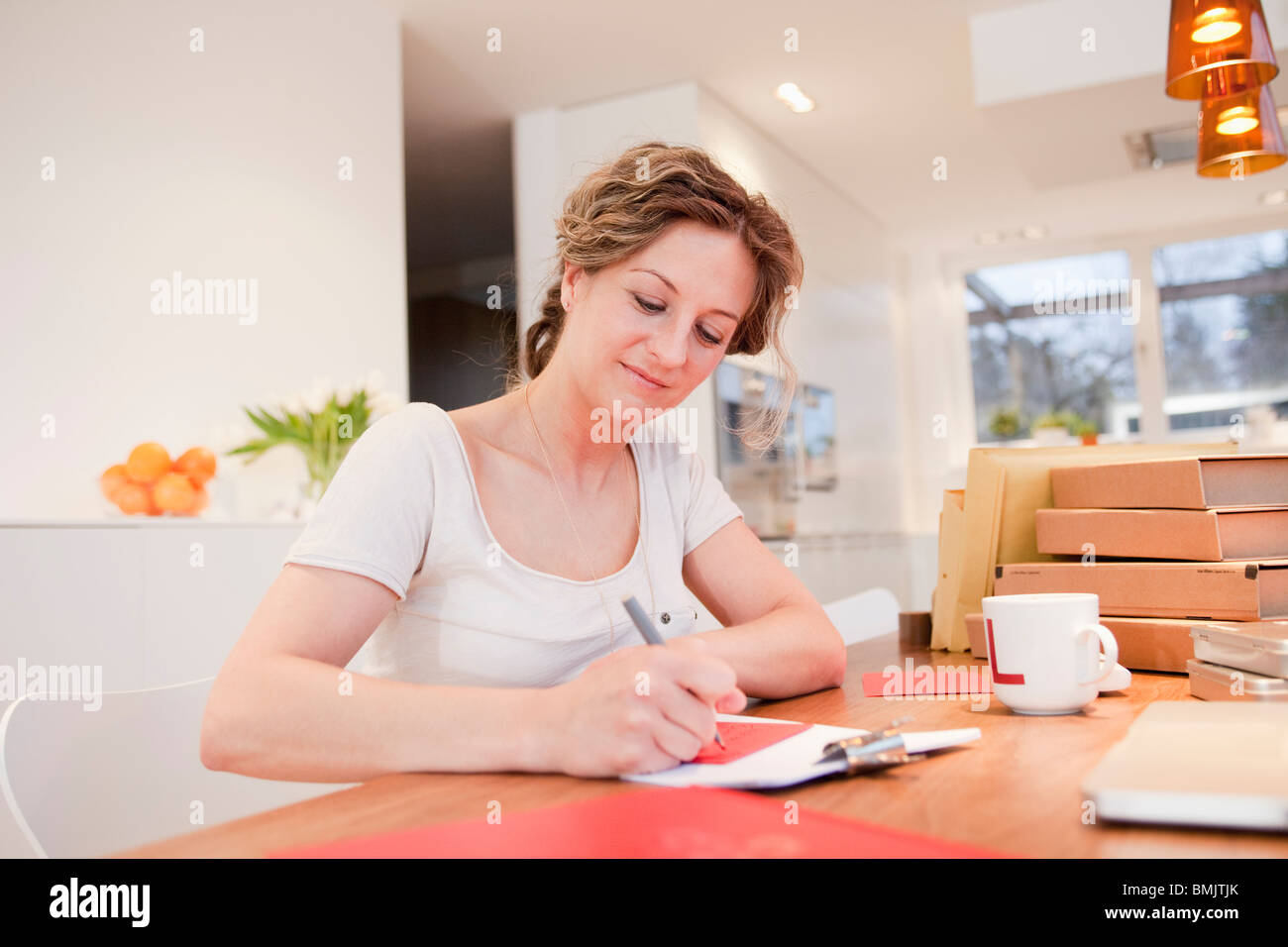 Woman writing address on an envelope Stock Photo - Alamy
