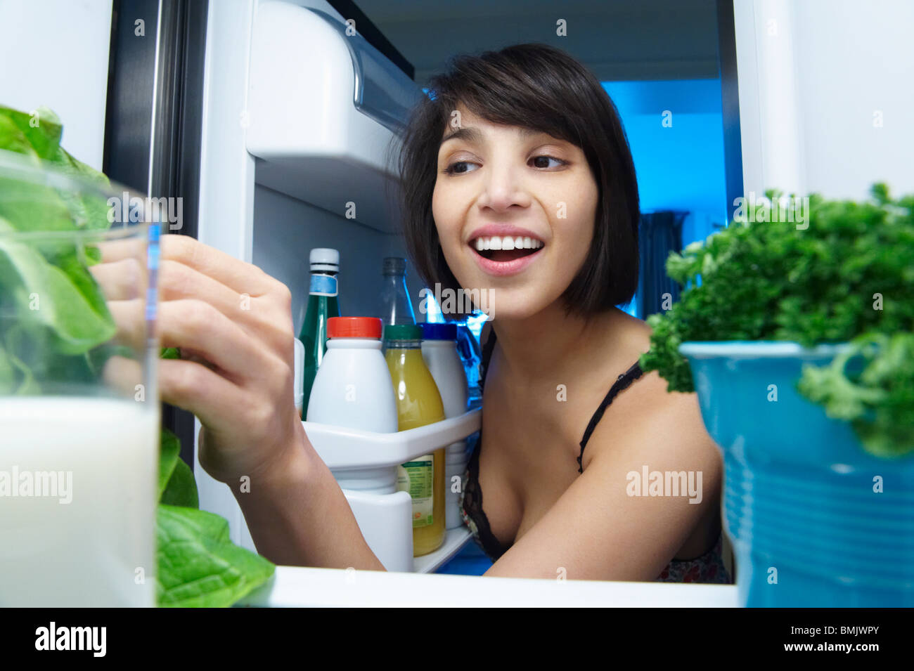 Woman looking into the fridge Stock Photo - Alamy