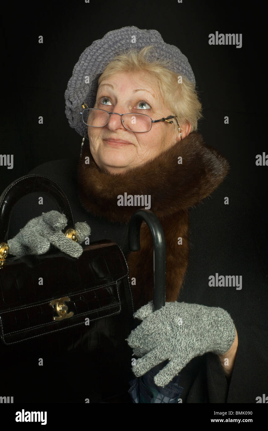 An elderly, very elegant and old fashioned lady dressed up with a very ...