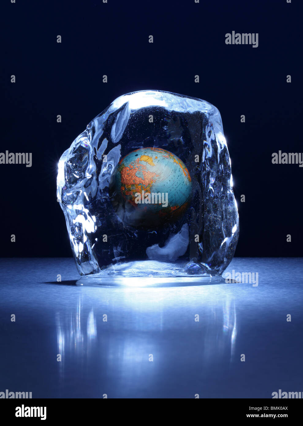 A frozen block of ice with a world globe frozen inside on a metal ...