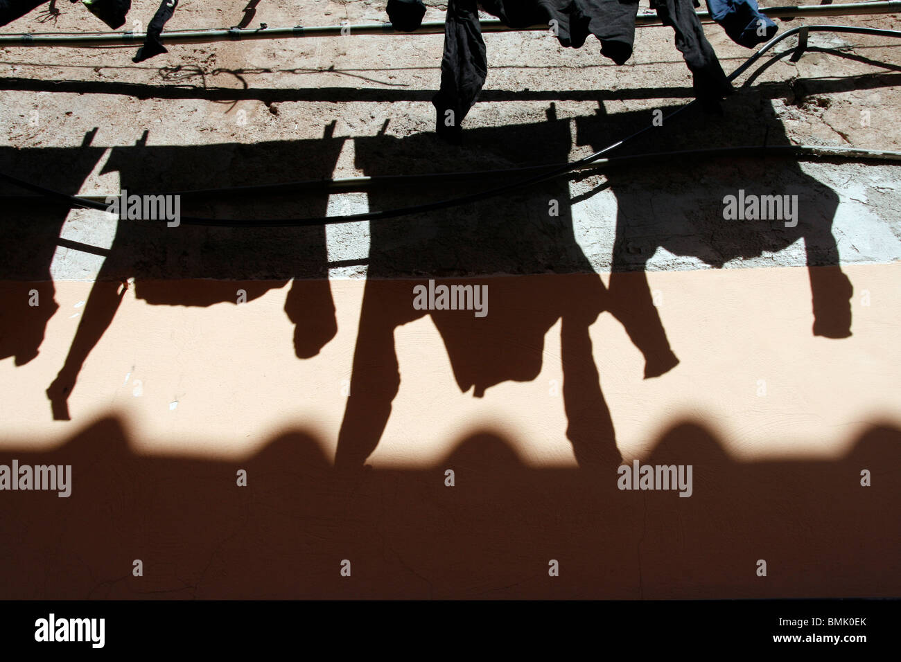 shadow of shirts hanging on washing line in sun Stock Photo - Alamy