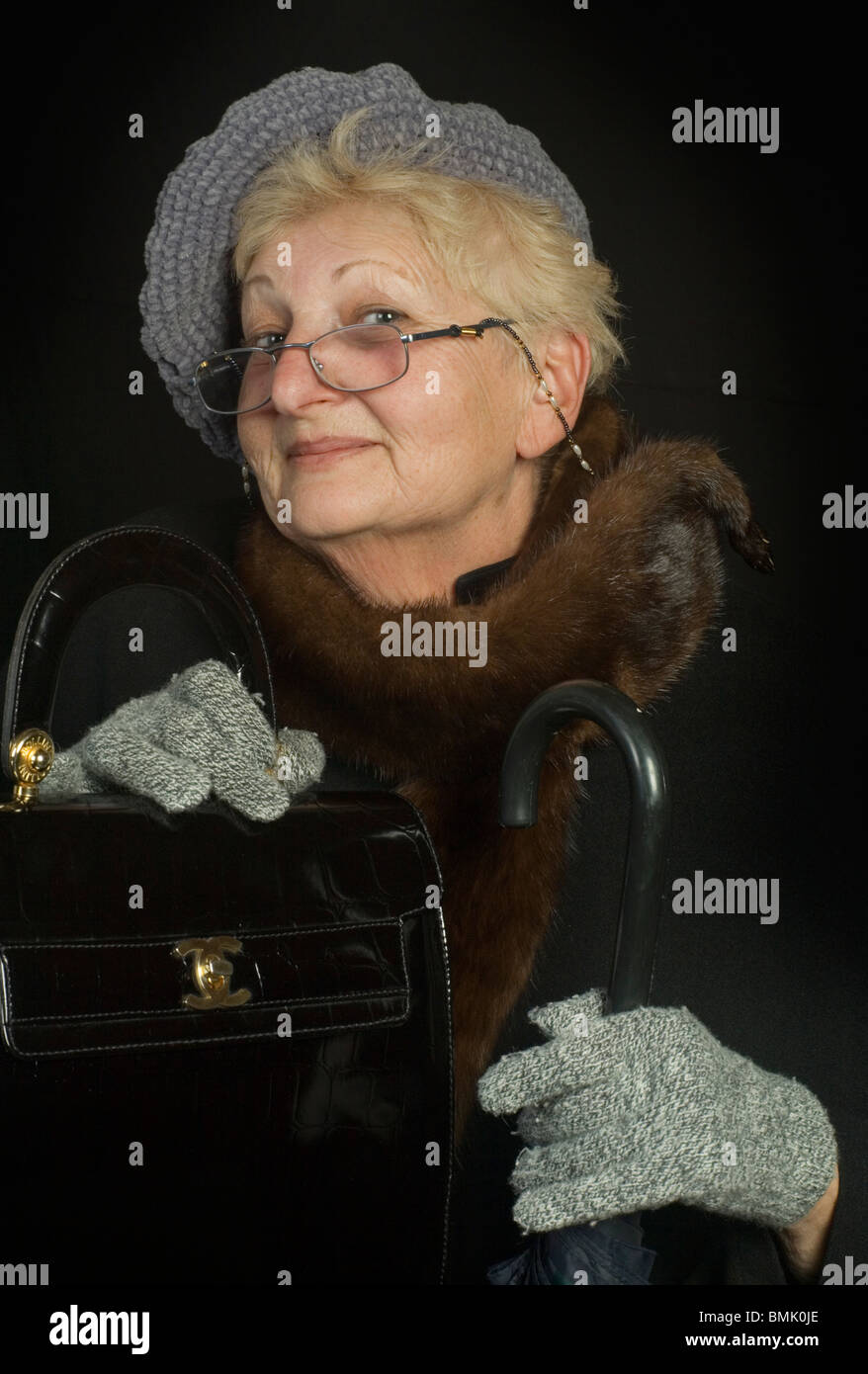 An elderly, very elegant and old fashioned lady dressed up with a very ...