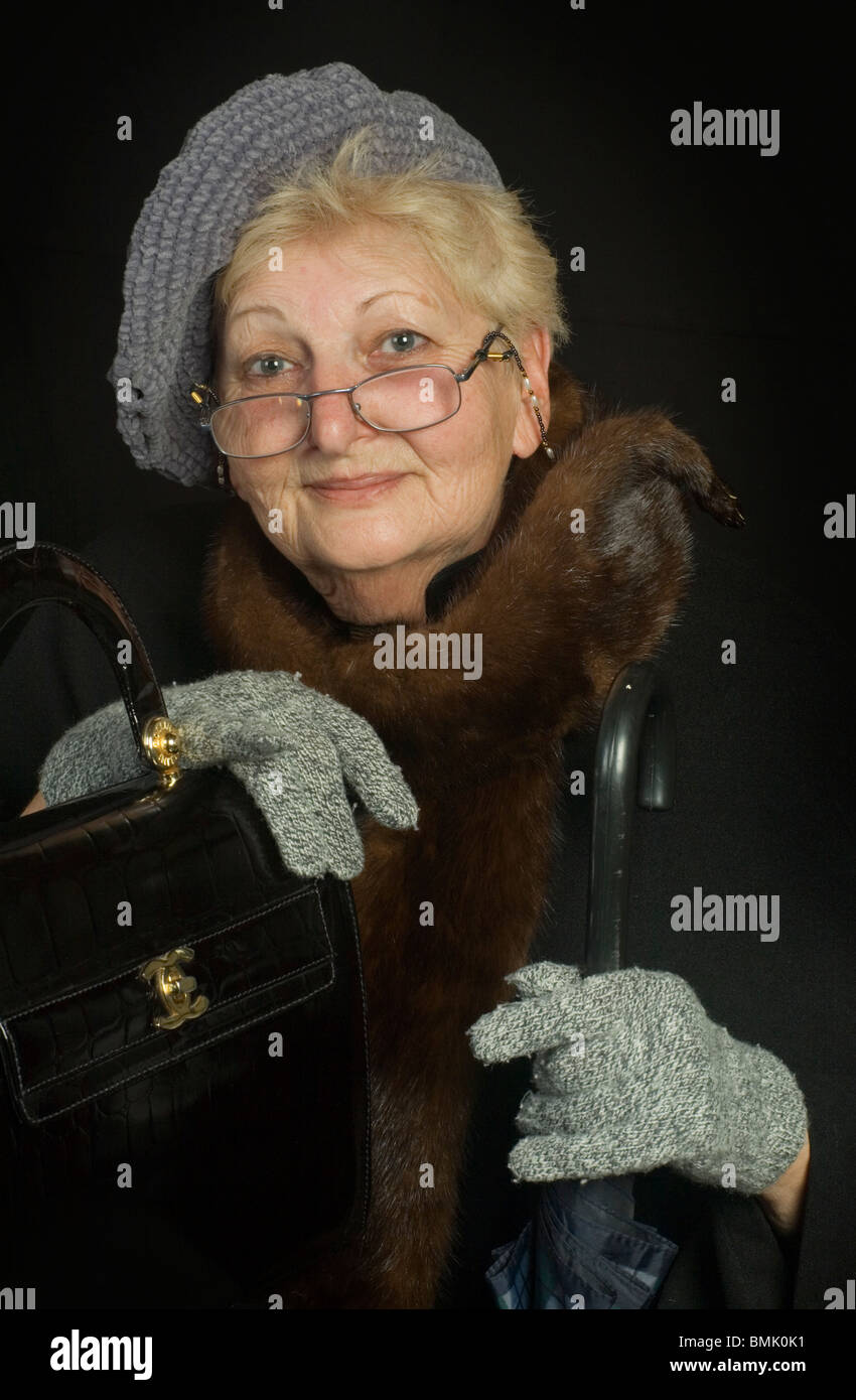 An elderly, very elegant and old fashioned lady dressed up with a very ...